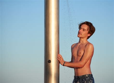 Premium Photo A Caucasian Male Taking A Shower At A Beach During The Day