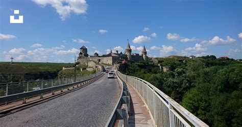 자동차가 있는 도로와 배경에 성이 있는 길 사진 Unsplash의 무료 캄야네츠 포딜키 이미지