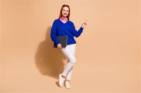 예쁜 아가씨 노트북의 전체 길이 초상화는 베이지 색 배경에 고립 된 손가락 빈 공간 착용 스웨터를 나타냅니다 20 24세에 대한 스톡 사진 및 기타 이미지 Istock