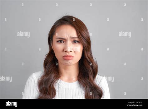 young beautiful sad woman serious and concerned looking worried and thoughtful facial expression ...