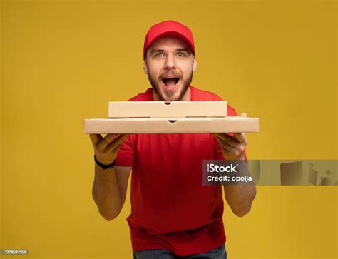 빨간 티셔츠와 모자를 쓰고 배달 서비스에서 행복한 남자 음식 주문을 주고 노란색으로 고립된 피자 상자를 들고 청년 성인에 대한 스톡 사진 및 기타 이미지 Istock