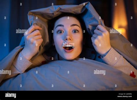 Surprised Teenage Girl Under Blanket In Bed Stock Photo Alamy