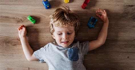 장난감 자동차를 가지고 집에 있는 바닥에 누워 있는 어린 소년의 모습 사진 Unsplash의 침실 이미지