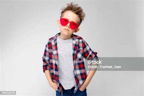 잘생긴 소년 격자 무늬 셔츠 회색 셔츠와 청바지에 회색 배경에 서 있다 빨간 선글라스에 소년 개념에 대한 스톡 사진 및 기타 이미지 Istock