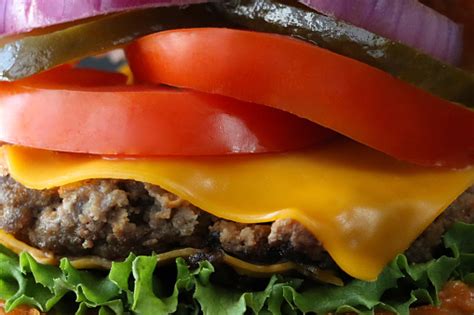 수제 치즈버거 햄버거 패티 녹는 가공 치즈 조각 양상추 잎 얇게 썬 토마토 피클 및 적양파 조각의 레이어의 전체 프레임 이미지