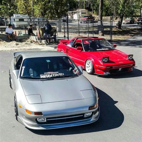 Two Cars Parked Next To Each Other In A Parking Lot