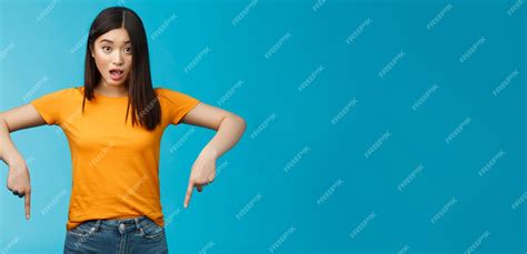 Free Photo | Impressed asian girl drop jaw shocked look camera surprised pointing down ...
