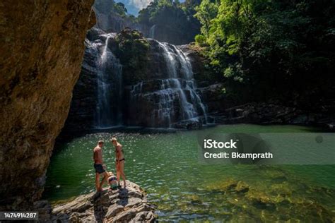 코스타리카 태평양 연안의 야생의 길들여지지 않은 해안의 아름다움에서 아름다운 Nauyaca 폭포를 즐기는 어머니 아버지 유아 딸