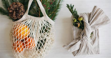 제로 폐기물 크리스마스 휴일 녹색 가지가 있는 린넨 패브릭으로 싸인 세련된 크리스마스 선물과 소박한 나무 배경에 녹색 가문비