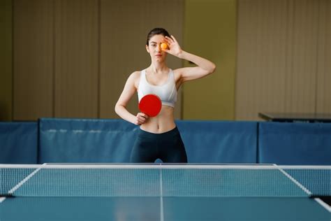 Premium Photo Woman With Racket Shows Ping Pong Ball Indoors