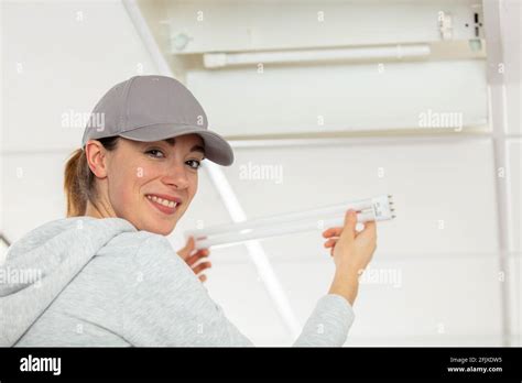 Woman Installing A Replacement Fluorescent Bulb Stock Photo Alamy