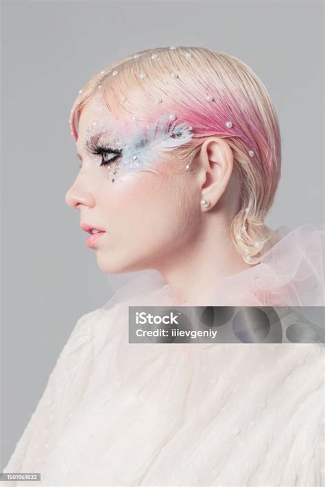 하얀 바탕에 스튜디오에서 하얀 블라우스를 입은 금발 소녀 짧은 분홍색 머리 스커트를 입은 모델 깃털로 뷰티 메이크업 스타일과 패션 오뜨 꾸뛰르 깃털에 대한 스톡 사진 및