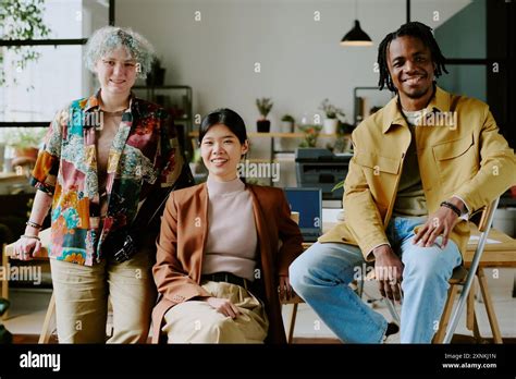 Group Of Three Diverse Gen Z Colleagues Wearing Stylish Outfits Posing For Camera In Modern Eco