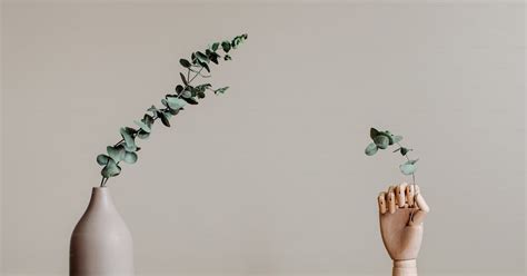 현대 꽃병에 마른 유칼립투스 가지와 실내 나무 테이블에 나무 손 텍스트를 위한 빈 공간입니다 현대 홈 인테리어 디자인 요소