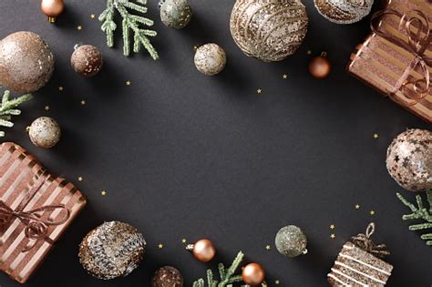 검은 배경에 우아한 선물 상자와 금 싸구려가 있는 크리스마스 프레임입니다 인사말 카드 또는 포스터를 위한 축제 휴일 구성입니다 청동색에 대한 스톡 사진 및 기타 이미지