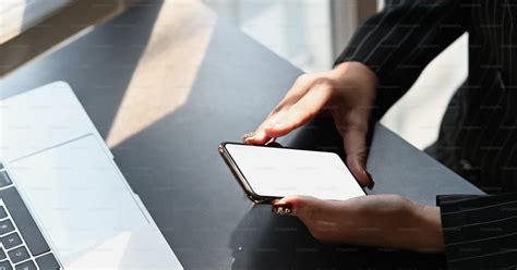 컴퓨터 노트북 편안한 사무실에서 작업 테이블에 놓는 커피 컵 앞에 앉아 스마트폰을 들고 있는 사업가의 손의 자른 이미지 질서 정연한 직장 개념 사진 Unsplash