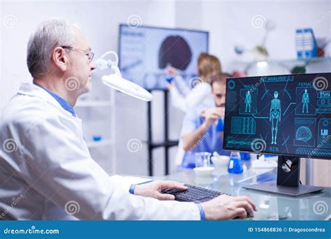 Experienced Senior Technician Working On Computer In A Laboratory
