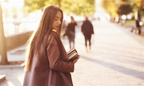 젊은 예쁜 갈색 머리 소녀 턱 아래 그녀의 두 손으로 벽에 기대어 복사 공간 흐린 배경에가을 화창한 공원 캐주얼 코트를 입고 가을에 대한 스톡 사진 및 기타 이미지 Istock