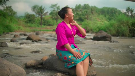 An Asian Woman With The Traditional Pink Dress And Green Skirt Sitting