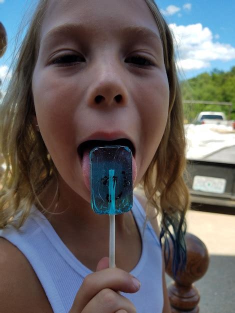 Premium Photo Close Up Portrait Of Girl Licking Lollipop