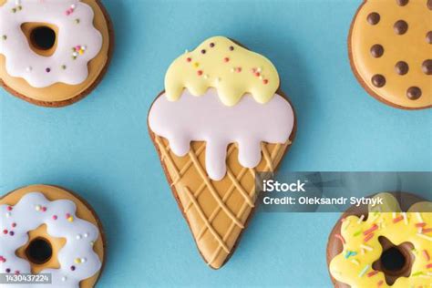 아이스크림 모양의 수제 진저 브레드 쿠키 파스텔 색상의 장식이있는 도넛 및 컵 케이크 빈티지 세련된 패스트리 배경 파란색 배경의 평평한 누워 냉동식품에 대한 스톡 사진 및