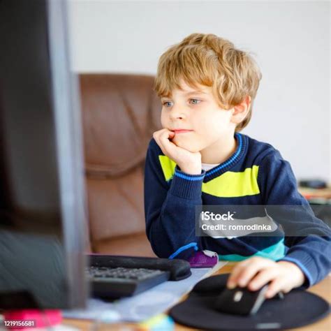 컴퓨터에 학교 숙제를 만드는 작은 학교 아이 소년 Pc에서 아이 학습 코로나 전염병에서 검역 시간 동안 운동을 하는 열심히 일하는 소년 홈 스쿨링 개념입니다 가정 생활에