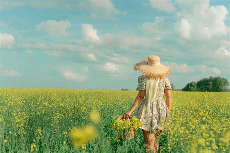 걷고 있는 경치 경치가 좋은 고요한 구름 국가 금발 꽃 꽃무늬 꽃무늬 드레스 꽃이 피는 농업 농촌의 뒷모습 들판 모험 목가적인 밀짚 모자