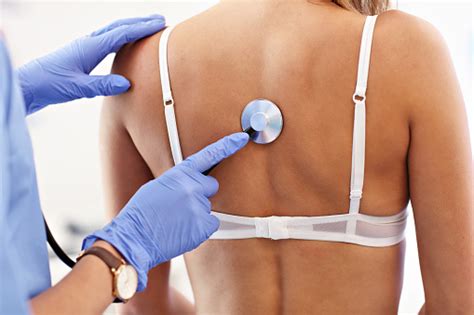 Adult Woman Being Examined With Stethoscope By Female Doctor Stock