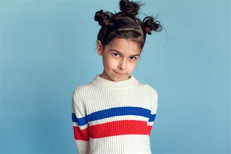 스튜디오 블루 배경 위에 서 재미있는 헤어 스타일을 가진 심각한 어린 소녀 아이는 그녀의 얼굴에 수줍은 표정을 가지고있다 심각한에 대한 스톡 사진 및 기타 이미지 Istock