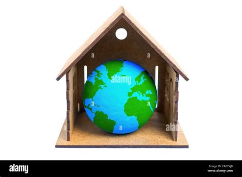 Close Up Of A Tiny Green And Blue Globe Nestled Inside A Miniature Wooden House Isolated On
