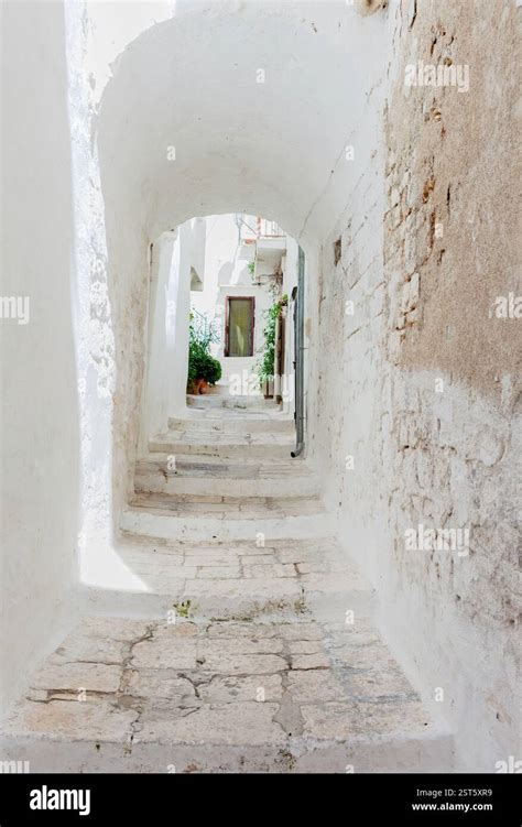 Narrow Whitewashed Alley With Arch And Stairs Leading To A Typical