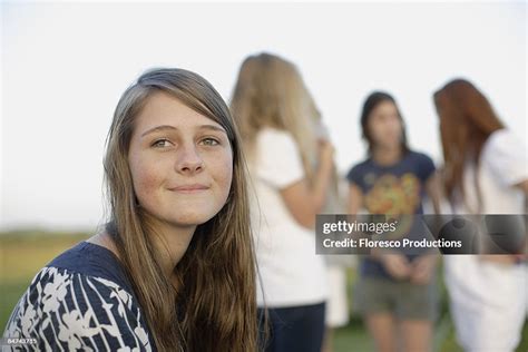 Teenager Girl Sitting In Front Of Socializing Friends High Res Stock