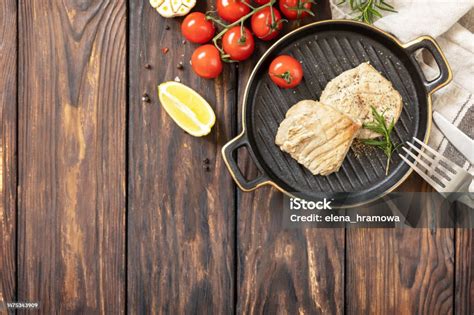 레스토랑 음식 해산물 소박한 스타일 돌판에 향신료 토마토 로즈마리를 곁들인 육즙이 많은 참치 스테이크를 요리했습니다 위에서 본 모습 공간을 복사합니다 0명에 대한 스톡 사진