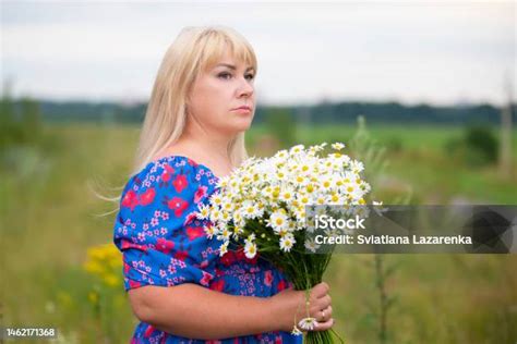 여름 드레스에 흰 머리카락을 가진 아름다운 플러스 사이즈 여성이 데이지와 함께 야외에서 포즈를 취합니다 꽃이있는 초원에있는 통통한 소녀 35 39세에 대한 스톡 사진 및