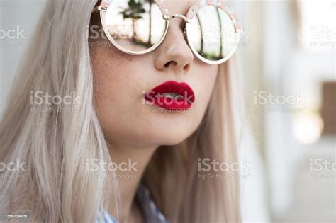 거리에서 카메라에 포즈를 취하는 긴 머리와 예쁜 금발 소녀의 초상화 그녀는 파란색 드레스와 안경을 착용 25 29세에 대한 스톡