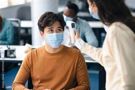 Teacher With Contactless Thermometer Measuring Temperature Of Asian Babe Stock Photo Adobe