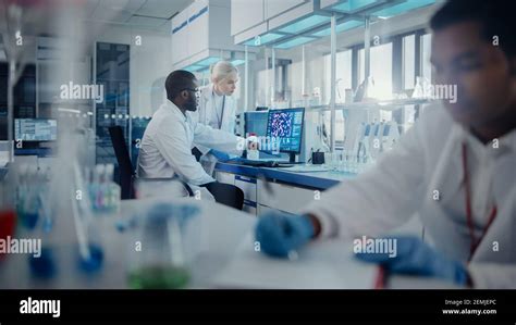 Modern Medical Research Laboratory Two Scientists Use Computer With