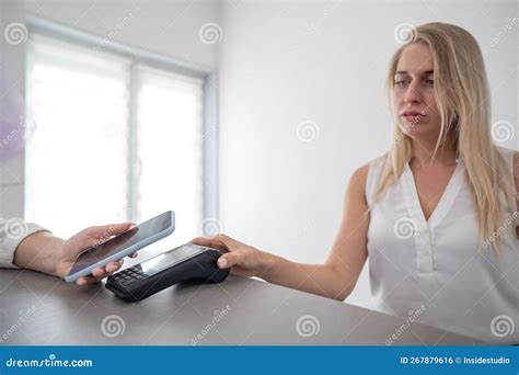 A Woman Pays Using A Non Contact Payment Of The NFC Used By A Smartphone Stock Photo Image