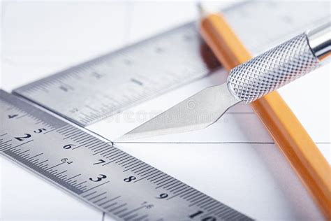 Cutting With Knife The Layout Of Engineering Drawing On Background With Rulers Architecture
