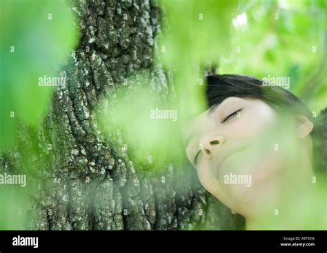 Woman Leaning Against Tree Stock Photo Alamy