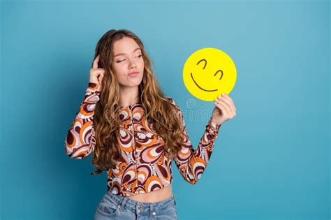 Photo Of Nice Young Girl Scratch Head Hold Emoji Wear Top Isolated On Blue Color Background
