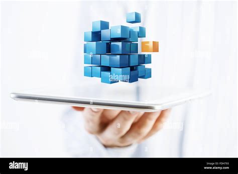 businessman holding tablet and cube as symbol of problem solving stock