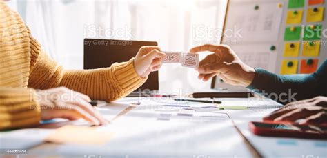 Ux 개발자와 Ui 디자이너가 사무실에서 고객 브리프와 색상 코드를 사용하여 모바일 앱 인터페이스 와이어프레임 디자인에 대해 브레인스토밍합니다 2명에 대한 스톡 사진 및