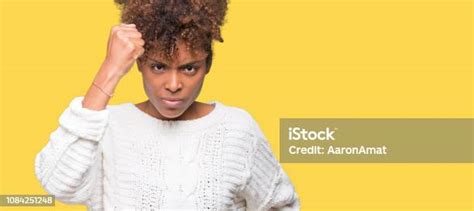 이상의 겨울 스웨터를 입고 아름 다운 젊은 아프리카계 미국인 여자 절연 배경 화와 좌절과 분노와 함께 외치는 동안 분노 주먹