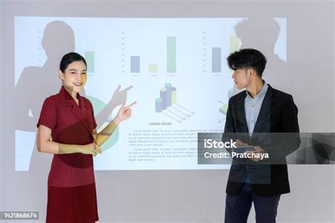 비즈니스 남성과 여자는 회의 중에 동료에게 프리젠 테이션을 큰 화면에 인포 그래픽 애니메이션을 보여줍니다 2명에 대한 스톡 사진 및 기타 이미지 Istock