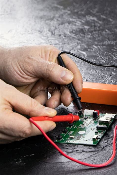 an electrician takes readings from a microcircuit using a multimeter