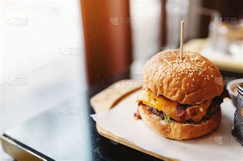 接近美味的汉堡在盘子上。不健康的饮食概念。