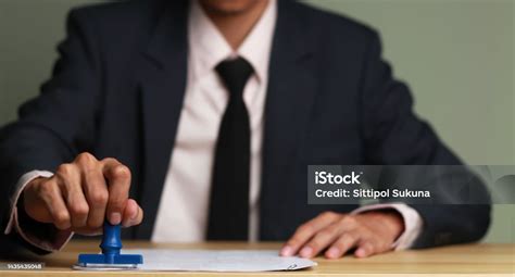 책상에 있는 공증 증명서 문서에 승인 스탬프를 찍은 사업가 변호사 사용 계약 수락 조약 조건 선택 스탬프 계약의 승인 경영자에