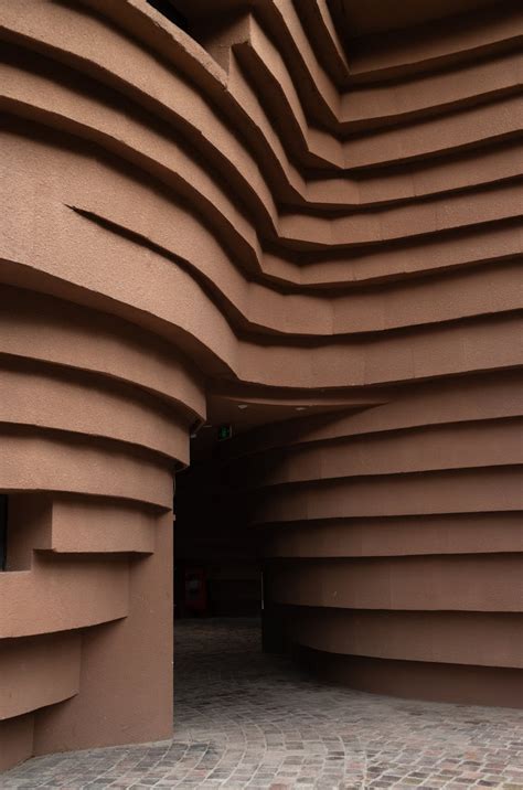 가벼운 갈색 건물 건설 건축 건축 세부 골이 진 공간 디자인 관념적인 구부러진 구조 그림자 기하학 대조 도시 디자인 도시의 디자인 모양