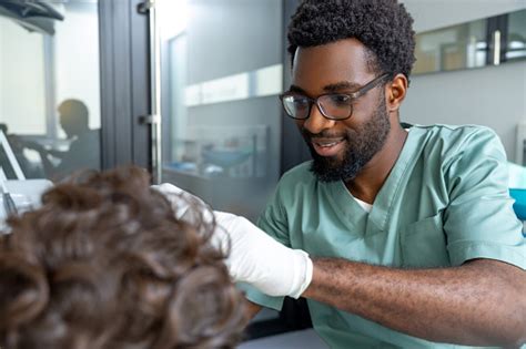 치과 진료실에서 교정 도구를 사용하여 검진 중 환자의 치아를 검사하는 남성 치과 의사 20 24세에 대한 스톡 사진 및 기타 이미지 20 24세 2명 30 34세